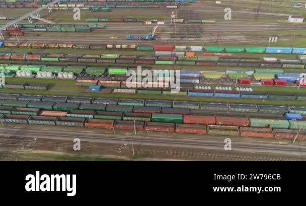 Fly over a large railway junction. Freight trains stand at the railway ...