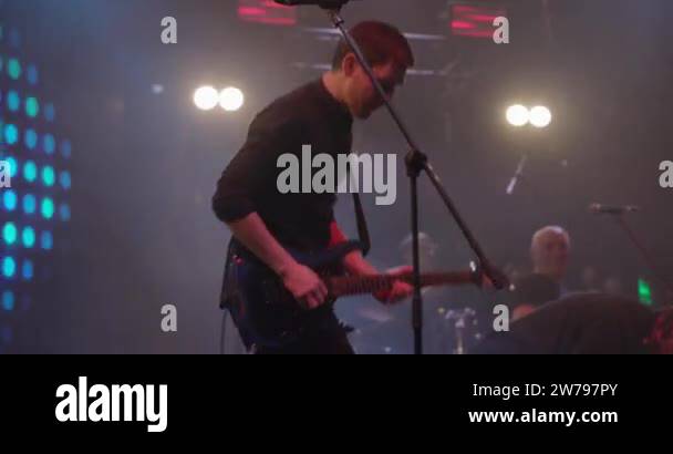 Live concert. Expressive guitarists performance on stage. The guy plays ...