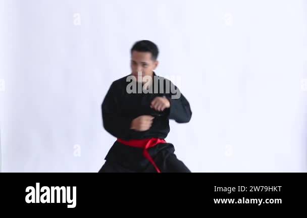 smiling Asian men wearing pencak silat uniforms stand up with pasang ...