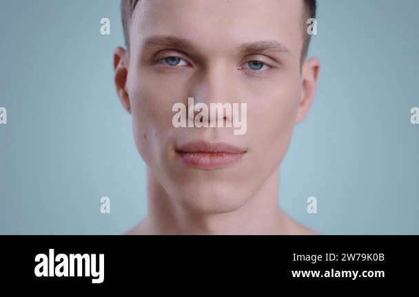 Headshot of positive handsome man opening eyes and looking to camera ...