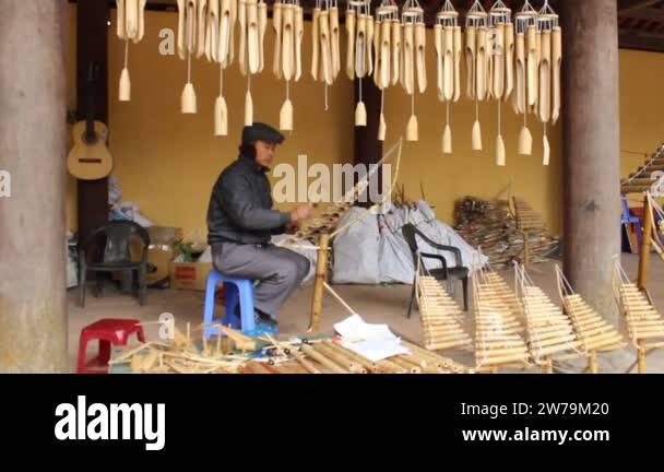 Asian man playing traditional instruments made of bamboo at folk ...