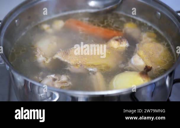 chicken broth is cooked on a gas stove, the cook collects fat Stock ...