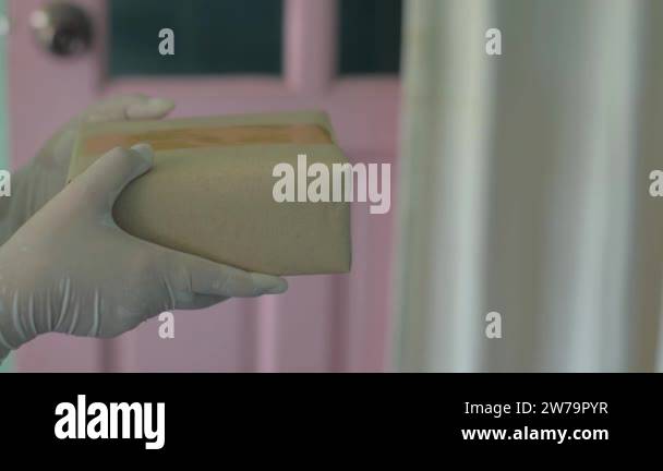 Close up of girl's hand receive a parcel from a delivery woman and ...