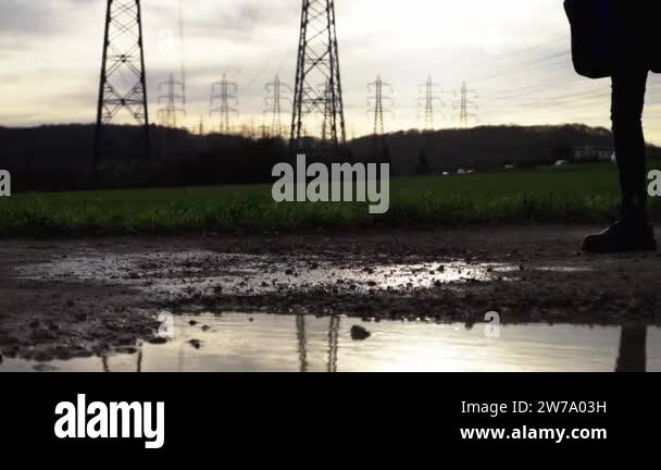 Static view stylish female woman in jeans and black boots walk over mud ...