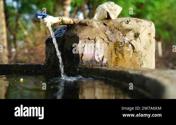 Flowing water on ground from a tap with extreme stream flow. Save water ...