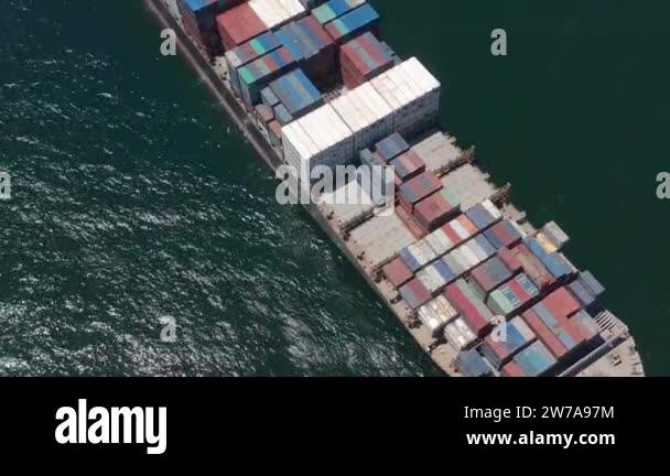 Aerial top view of cargo ship carrying container and running with tug ...