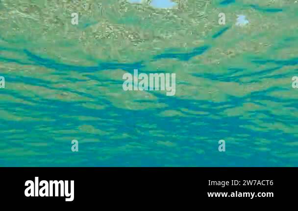 On water surface reflection from the sandy bottom. Close-up of water ...