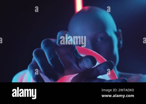 Studio shot of young bald woman with glowing neon tubes wrapped around ...