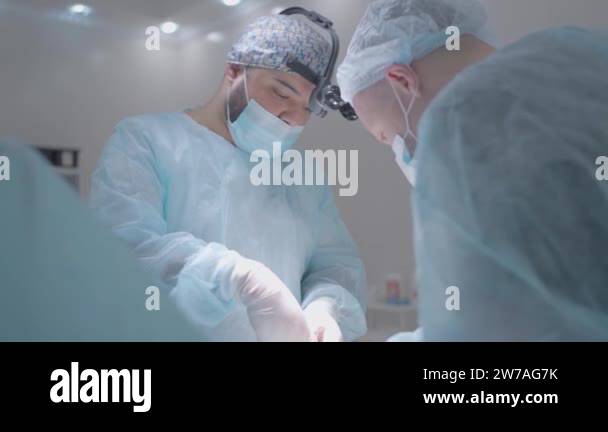 Surgeons perform difficult operation. Action. Two surgeons are ...