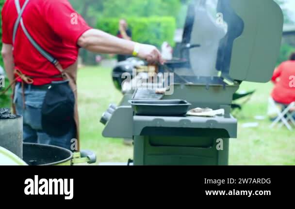 People celebrating weekend barbecue outdoors, man roasting assortment ...