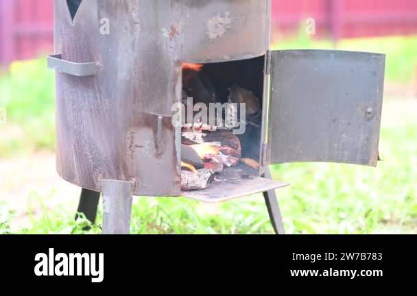 firewood burns in a fire with a red flame in a stove at a summer ...