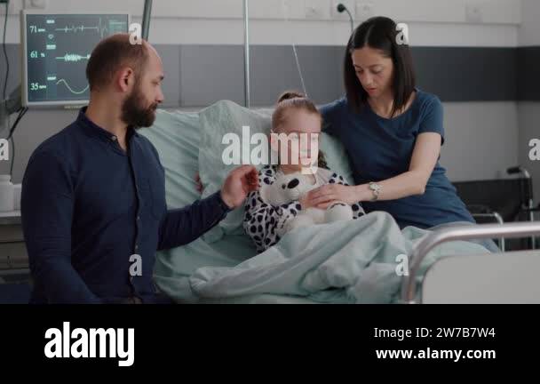 Sick daughter with oxygen nasal tube resting in bed after suffering ...