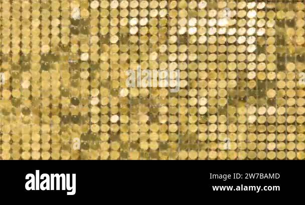 rows of blinking golden yellow brass metal plaques sway in wind and ...