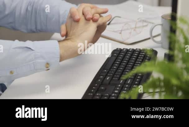 Man types on keyboard and kneads his hands. Close up. Touch-typing ...