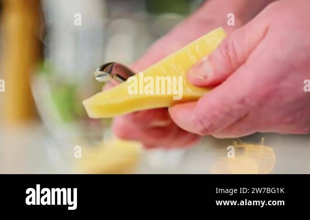 The male chef cut and rubs the hard parmesan cheese with a special ...
