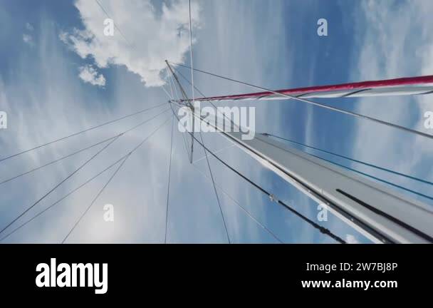 The bottom view on a mast of the sailboat, a sail are curtailed, a ...