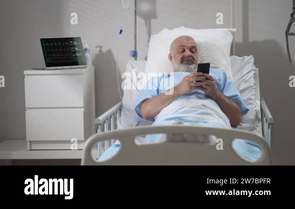 Male Patient Using Mobile Phone In The Ward At Hospital. Senior Male ...