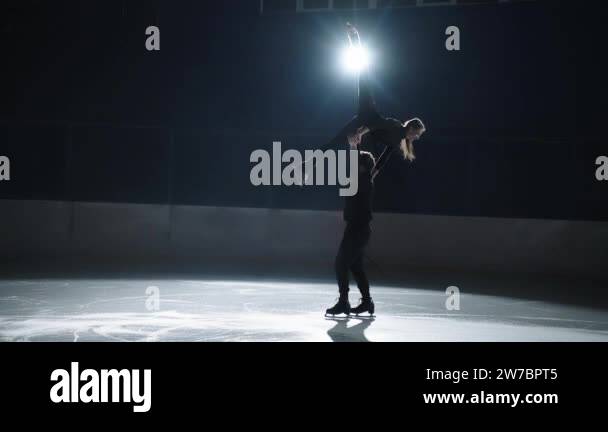 Slow motion: young couple of artistic figure skaters is performing a ...