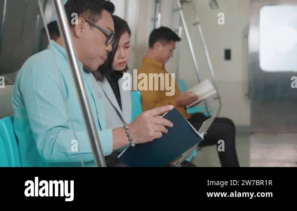 Young Asian business woman and man sitting using laptop computer ... Young Asian business woman and man sitting using laptop computer ...