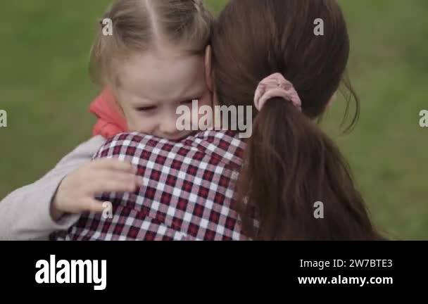 Mommy soothes baby. child is crying in park in arms of mom. family ...