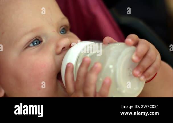 lovely little girl with blue eyes drinking milk from a bottle Stock ...