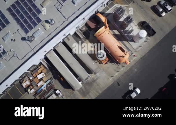 A Descending birds eye view above building loading dock with orange ...