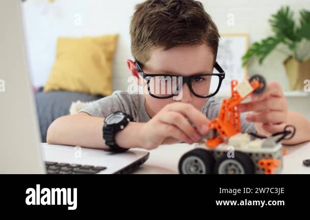 Child learns coding and programming on a laptop. Boy looks with ...