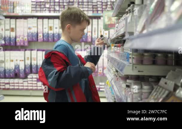 a boy in a red jacket picks out paint on the counter. we look at the ...