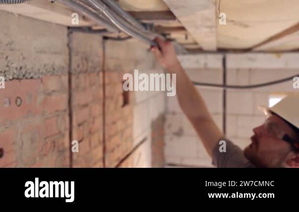 Fixing plastic tubes for electrical wires in the ceiling in wiring ...