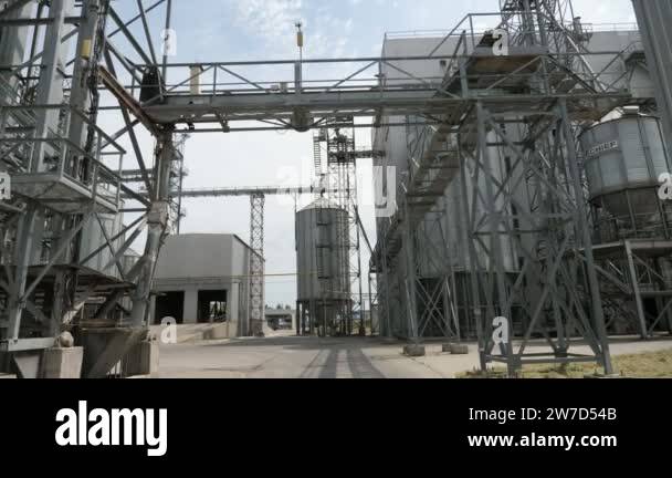 Large soy bean oil plant wilh high vats and metallic ladders on grey ...
