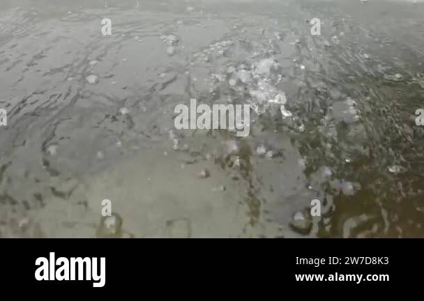 Rain water drops falling into big puddle on asphalt, flooding the ...