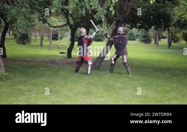 Battle of two medieval warriors in full sets of armor with swords and ...