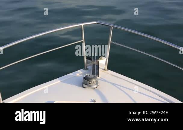 bow of a white yacht with iron chrome handrails and a chain with an ...