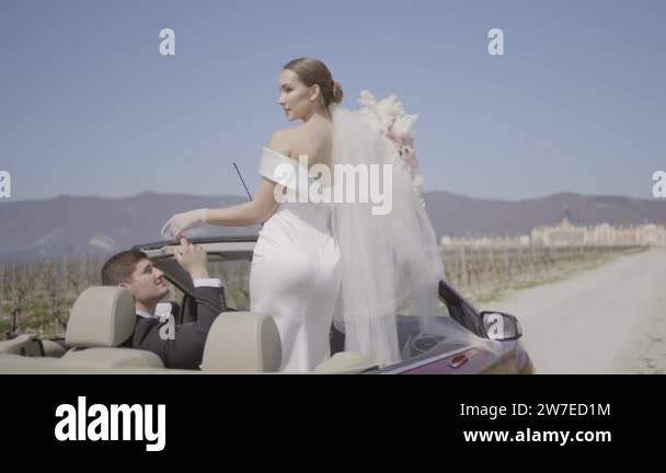 Beautiful newlyweds in car. Action.Stylish and charismatic newlyweds in ...