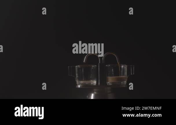 Heat vapor emitted from the coffee machine. Two glass coffee cups on a ...