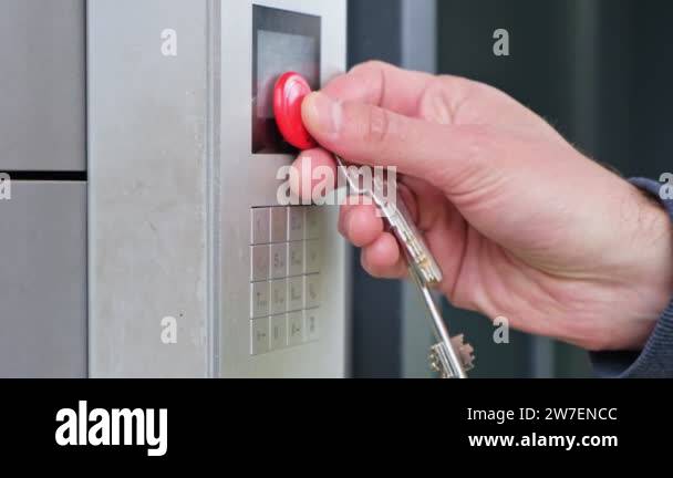 Male using intercom at residential building entrance. opens electronic ...