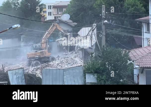 Excavator, destroying an old brick house. The hydraulic shovel of the ...