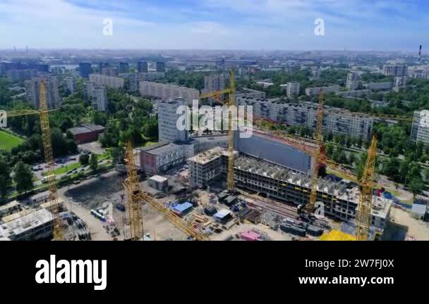 Flying over construction site. Top view of yellow tower cranes mounted ...