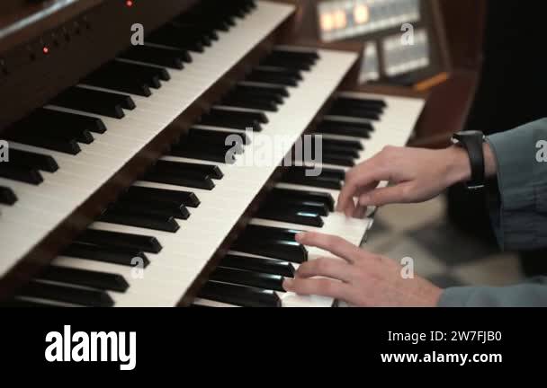 Close-up shot of nuns hands playing the piano key of church organ ...
