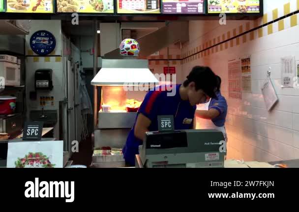 Worker packing chicken and fries for customer inside Church's chicken ...