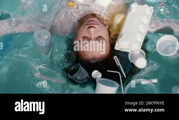 Incredible cinematic top view, young woman lying on water surface, eyes ...