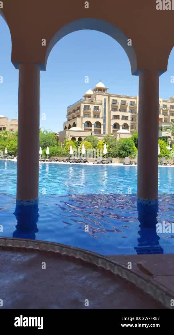 Wind ripples pool water at luxury resort on poolside with Arabic style ...