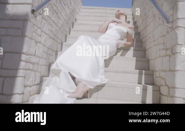 Stylish bride on steps. Action. Bride with elegant dress is sitting on ...