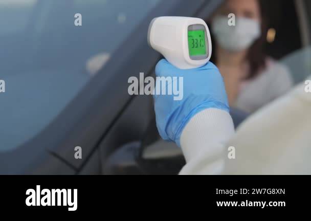 Measuring temperature of a driver with contactless thermometer, COVID ...