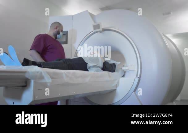 The doctor conducts an MRI or PET scan of a patient in a modern clinic ...