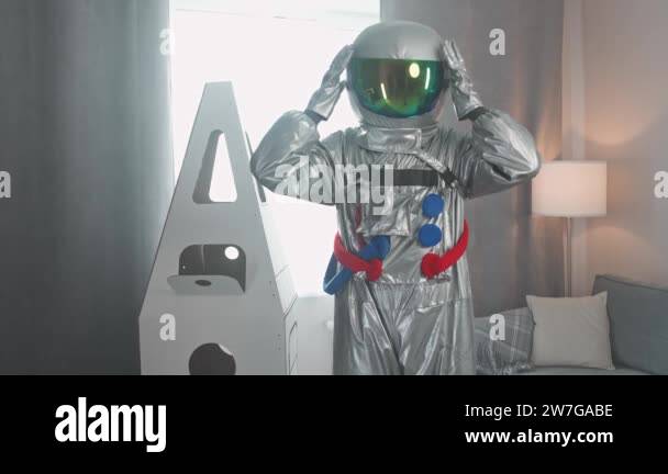 Spaceman, middle-aged man in an astronaut suit stands in living room ...