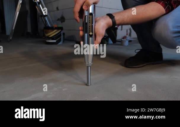 man holds the mechanism in his hands and puts it to the floor. non ...