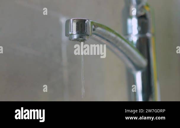 Water drips from the tap. Projecting crane close-up. Tap water drips ...