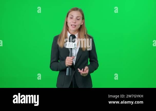 Breaking news, female news reporter speaks into a microphone on a green ...