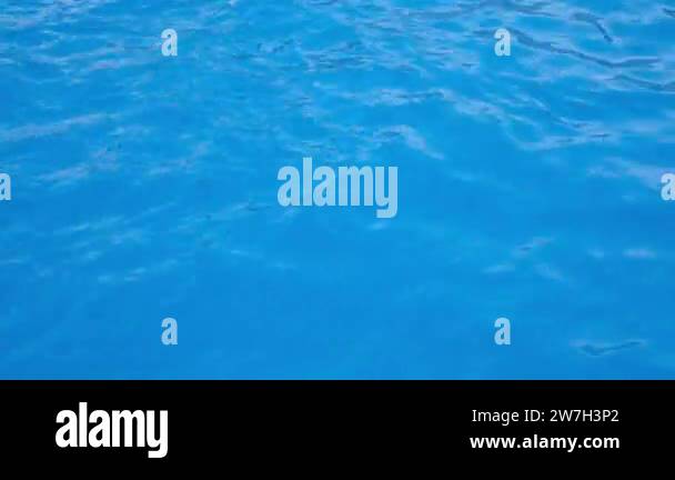 Pure transparent bright blue water in the swimming pool with light ...